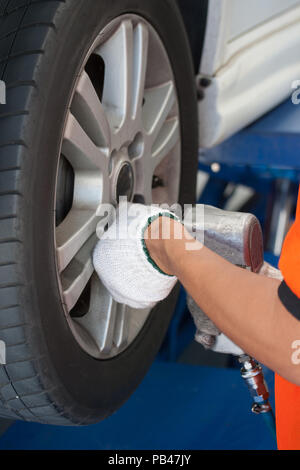 car mechanic screwing or unscrewing car wheel Stock Photo - Alamy