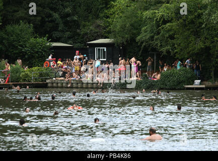 People swimming at the mixed bathing pond on Hampstead Heath, London, as heatwave conditions ...