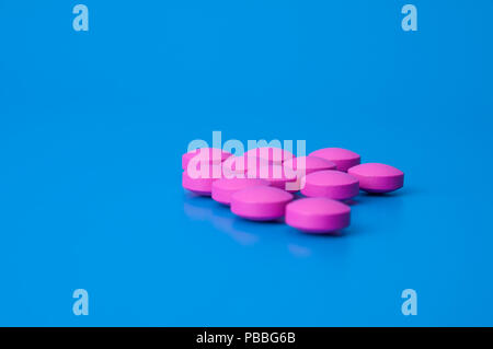 Closeup pink-white and blue-white antibiotics capsule pills in blister ...