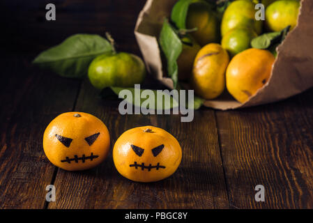 Scary tangerines for Halloween and bunch of tangerines on background ...