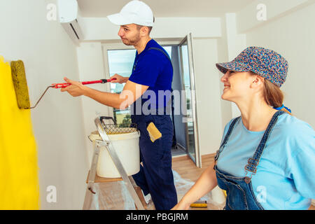 Cheerful couple renovate their new home with yellow color Stock Photo ...