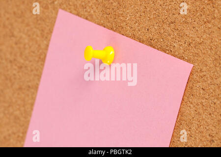 Pink paper pined with yellow tack on brown cork board background Stock ...