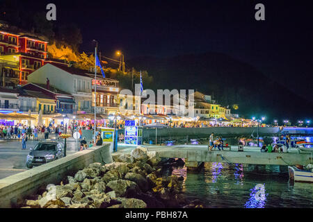 The amazing coastal city of Parga at night. Tourists and visitors walk ...