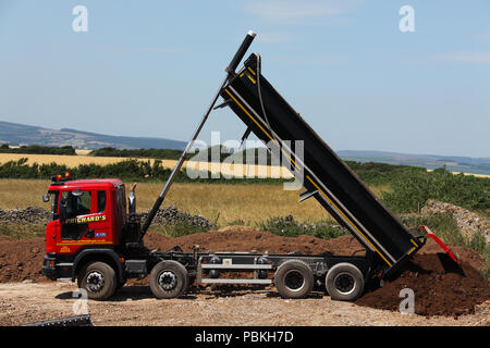 Anew tipper lorry delivering its full load of fresh earth during ...