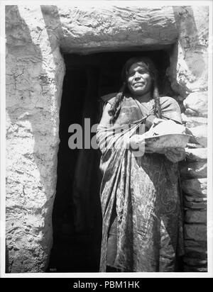 A Hopi Indian woman holding a stone for house construction in the ...