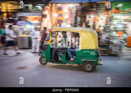 Indian auto rickshaws driving through wet streets in Puttaparthi ...