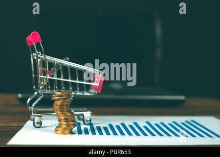 Step of coins stacks with trolley and notebook laptop computer and ...