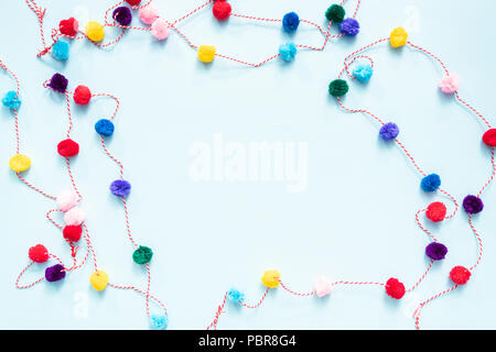 Pom pom colorful party garland on blue backgrouns Stock Photo - Alamy