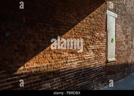 Back alley brick wall shadow patterns Stock Photo - Alamy