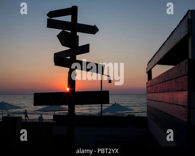 Multiple signs pointing in different directions on a beach in Cyprus ...