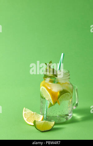 Homemade sparkling lemonade with ice, slices of lime and lemon, leaf of ...