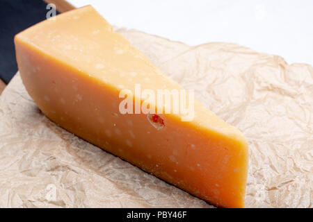 Piece of hard matured 3 years old dark yellow cheese close up Stock ...
