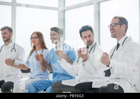 doctors sit in a row and hold hands of each other Stock Photo - Alamy