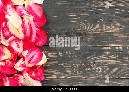 Scattered tulip petals on empty wooden background Stock Photo - Alamy