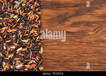 Scattered black wild rice on wooden background, top view Stock Photo ...