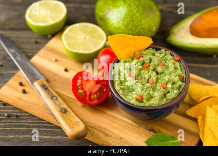 Guacamole in blue bowl on natural rustic desk with ingredient: lemon ...