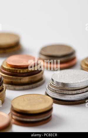 Close-up of various coins stacked on top of each other on a black ...