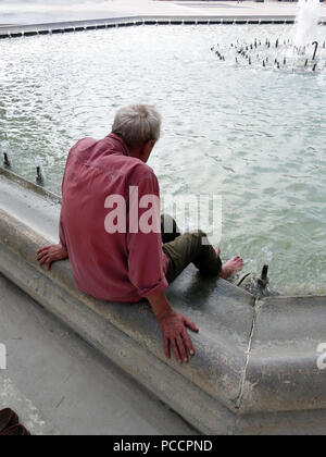 old man feeling hot and uncomfortable in the heatwave tries to keep ...
