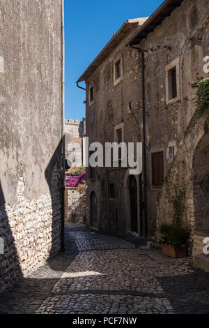 Medieval town alley with the wall of a castle in the background Stock ...