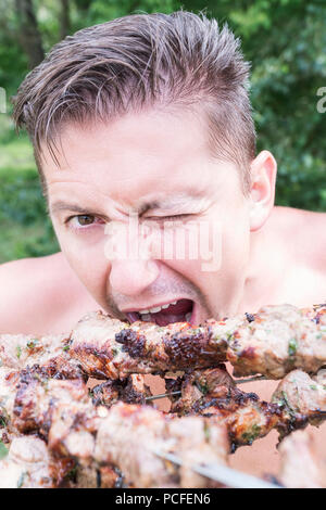 Man grilling shish kebab outdoor in park Stock Photo - Alamy