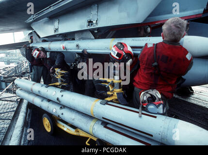 Aviation ordnancemen position an AIM-7 Sparrow air-to-air missile on ...