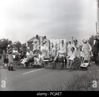 1960s, historical, English village pram race, two male competitors in ...