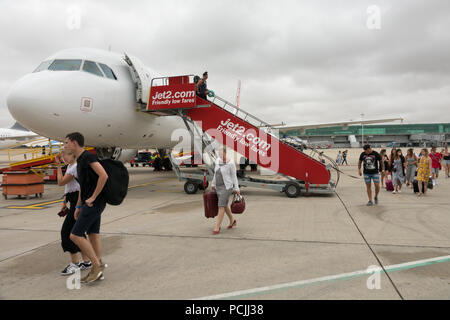 Passengers getting off aircraft and luggage unloading Stock Photo - Alamy
