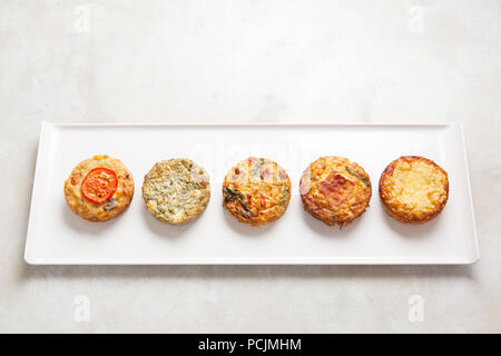 Individual mini quiches on a white rectangular plate Stock Photo - Alamy