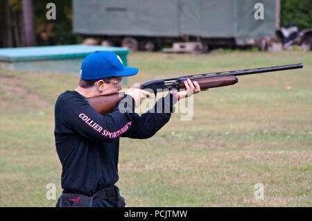 A young man taking aim on the line trap shooting at the Collier's ...