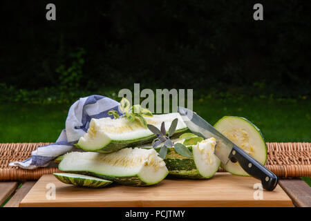 Chopped large spotted zucchini in the garden on the table Stock Photo ...