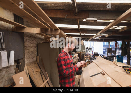 Carpenter using digital tablet in workshop Stock Photo - Alamy