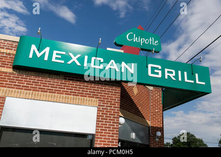 A logo sign outside of the first Chipotle fast casual restaurant ...