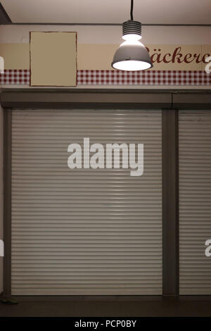 A closed bakery shop with lowered window blinds Stock Photo - Alamy