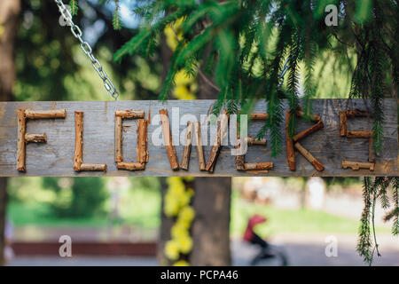 Word FLOWERS made of dry branches on the wooden sign Stock Photo - Alamy