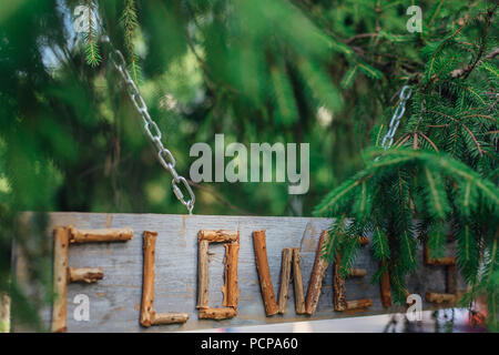Word FLOWERS made of dry branches on the wooden sign Stock Photo - Alamy