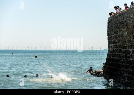 Young people enjoy cooling off at Brighton beach in the late afternoon ...