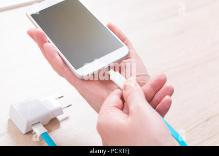 Hand connecting USB charging cable to the smart phone Stock Photo - Alamy