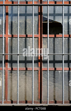 A barred window with broken glass Stock Photo - Alamy