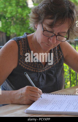 Mature woman making notes on flipchart to present her report for ...