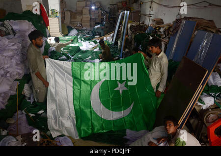 Lahore, Pakistan. 03rd Aug, 2018. Pakistani workers sorting national ...