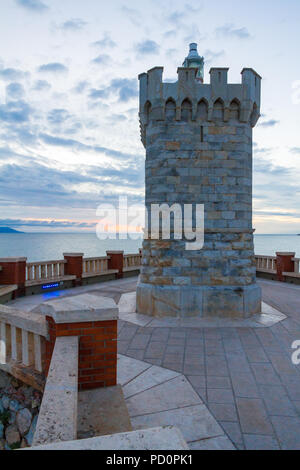 The lighthouse tower of Piazza Bovio in Piombino at sunset. Scenic view ...