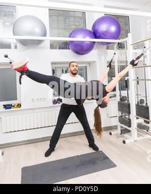 Woman exercising with hanging fitness straps Stock Photo - Alamy