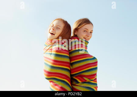Two Smiling Girls With Arms Wrapped Around Legs Stock Photo - Alamy