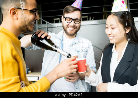 man in glasses and party cap with funny face expression holding cupcake ...