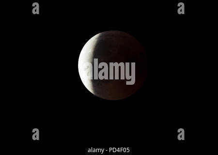 The lunar eclipse full crescent super moon rising against the dark sky ...