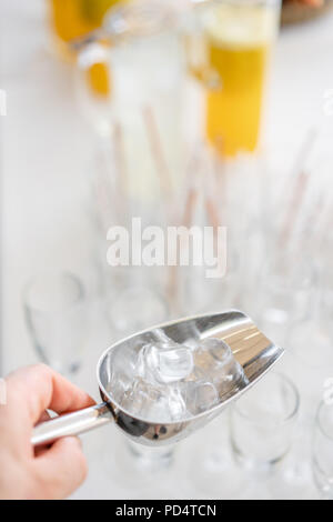 A metal ice bucket with full of crushed ice and stainless scoop for ...