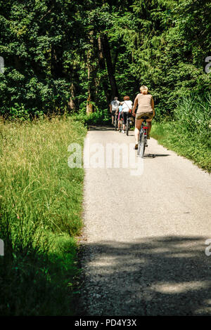 People enjoying a leisurely bicycle ride in rural Austria on a summer's ...