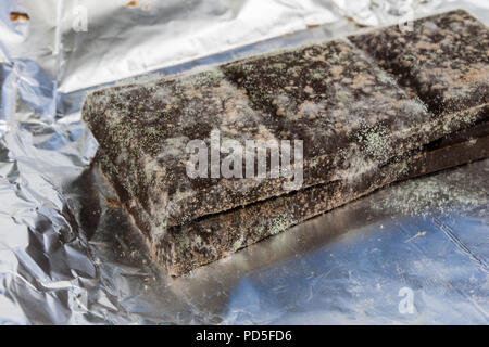 Moldy chocolate in the original packaging. Out-dated food products used ...