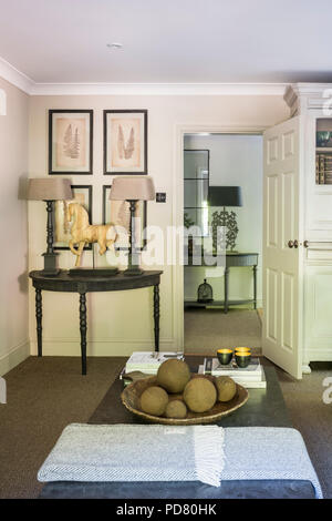 Antique lamps on demi lune table with framed designs in 18th century ...