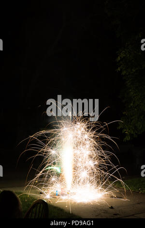 Ground spark shower fireworks or firecrackers in home driveway at night ...